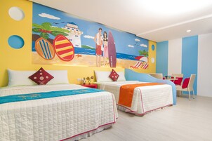 Quarto de hotel com duas camas, um mural de uma praia e uma pequena mesa com uma cadeira.