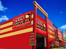Um edifício vermelho com várias placas anunciando um hotel e serviço de atendimento direto.