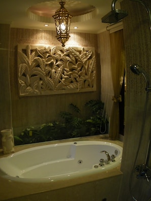 Um polibã e uma banheira separados, um secador de cabelo, chinelos