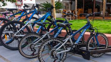 Uma fileira de bicicletas estacionadas em frente a um prédio com uma placa que diz 'HOTEL NINFA'.