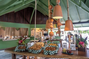 Uma mesa de buffet com diversos alimentos e uma máquina de café.
