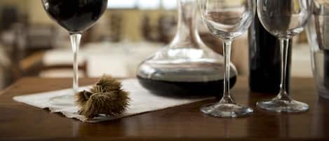 Uma mesa com copos de vinho e uma garrafa, uma escova de pele e um castiçal.