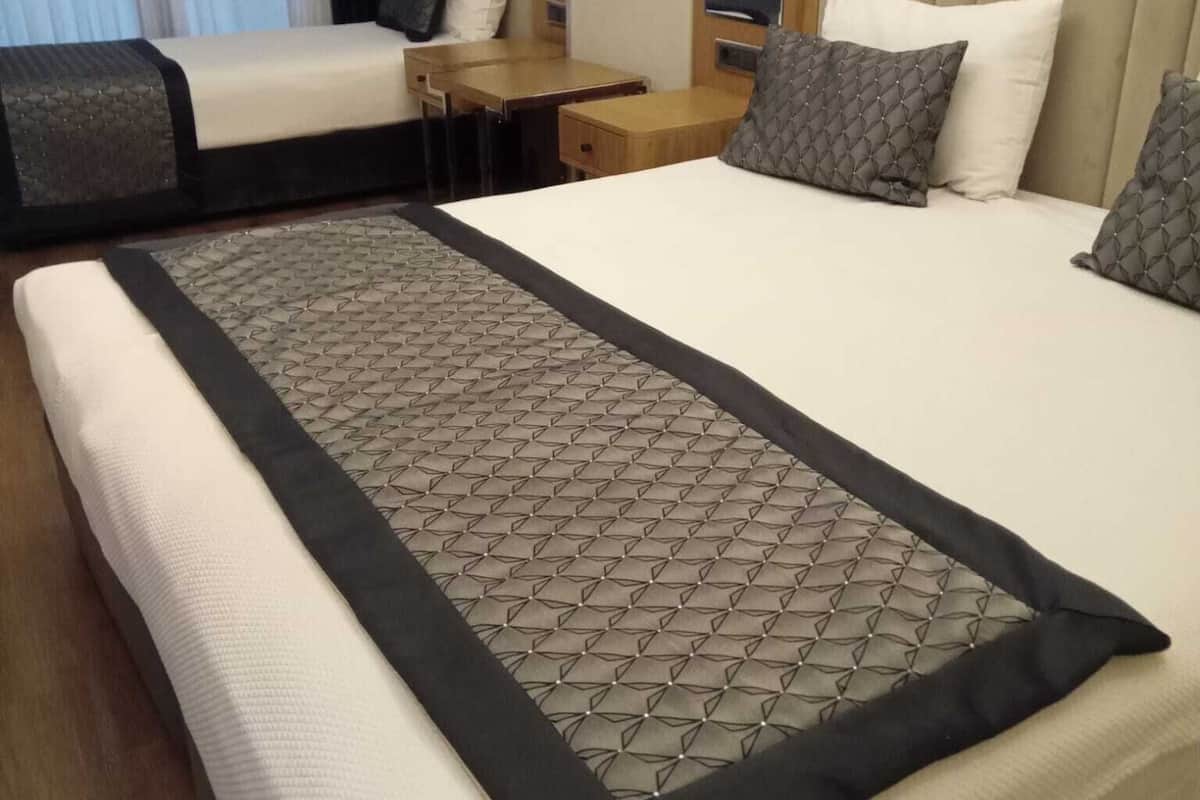 Quarto de hotel com uma cama grande, uma escrivaninha e uma cadeira.