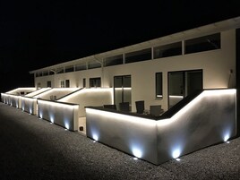 Um edifício moderno com vários balcões de atendimento e áreas de estar, iluminado por luzes indiretas.