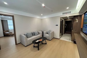 Uma sala de estar moderna com um conjunto de sofá, uma mesa de centro e uma televisão.