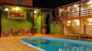 Área de piscina ao ar livre com espreguiçadeiras e piscina.