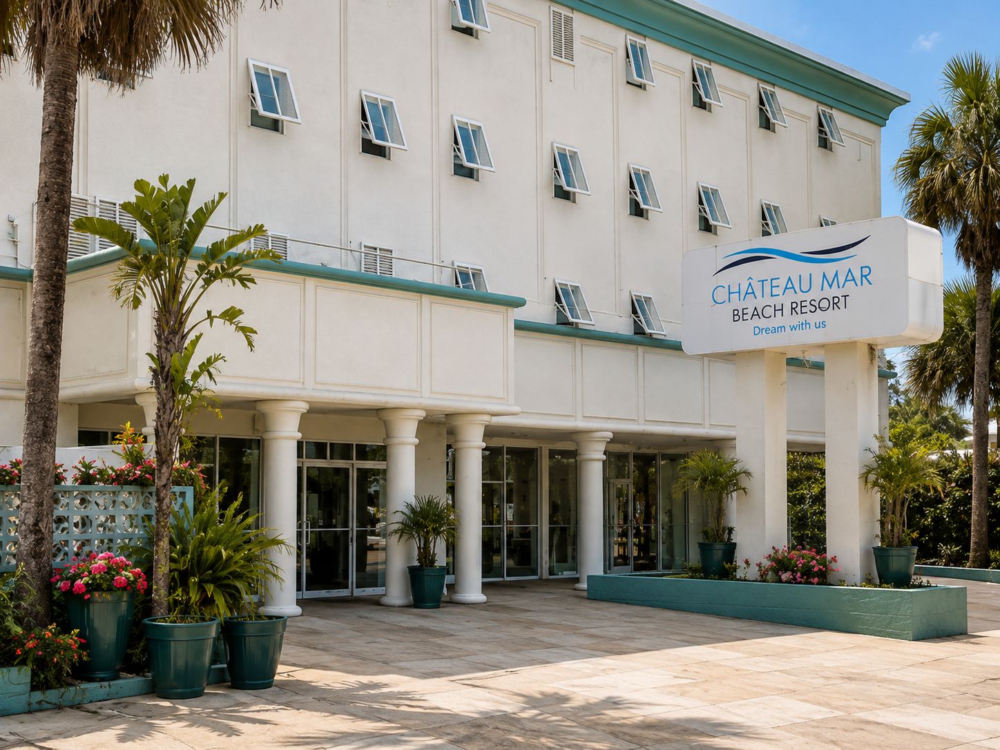 Entrada de um hotel com uma placa indicando 'Chateau Mar Beach Resort'.