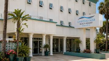 Entrada de um hotel com uma placa indicando 'Chateau Mar Beach Resort'.