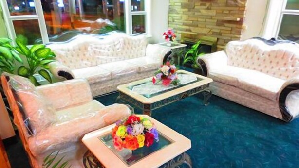 Um quarto com um conjunto de sofá, uma mesa de centro e uma mesinha com flores.