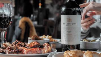 Uma garrafa de vinho tinto Salentein Reserva Malbec 2020, um prato com carne grelhada e uma taça de vinho tinto sobre uma mesa.