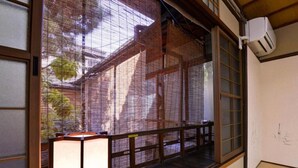 Um quarto japonês tradicional com tatames, um painel shoji e um varanda de madeira.