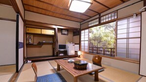 Um quarto japonês tradicional com soalho de tatame, uma mesa baixa e painéis shoji.