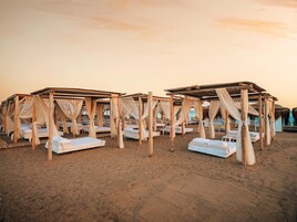 Uma praia privada, espreguiçadeiras, guarda-sóis de praia 