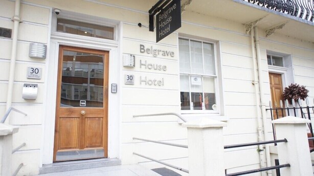 Um edifício com uma placa indicando "Belgrave House Hotel" e o número "30" na porta.