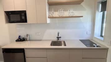Um frigorífico, um micro-ondas, uma placa de cozinha