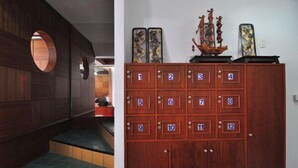 Uma escada de madeira com um recorte circular e um armário de madeira com compartimentos numerados.