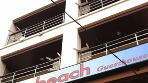Uma pousada chamada 'Starbeach Guesthouse' com varandas e uma placa indicando uma área 'HOTEL'.