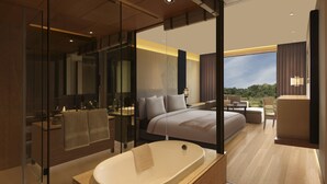 Quarto moderno com cama grande, banheiro separado com banheira e vista para o exterior.