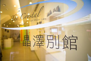 Placa de hotel com a inscrição 'The Crystal Sun Moon Lake' e caracteres chineses.