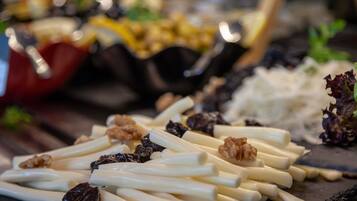 Diversos queijos e frutos secos sobre uma tábua de ardósia.