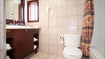Casa de banho com lavatório, espelho, porta-toalhas, sanita e cortina de chuveiro.