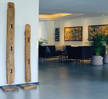 Um hall moderno com arte abstrata, uma área de recepção e assentos.