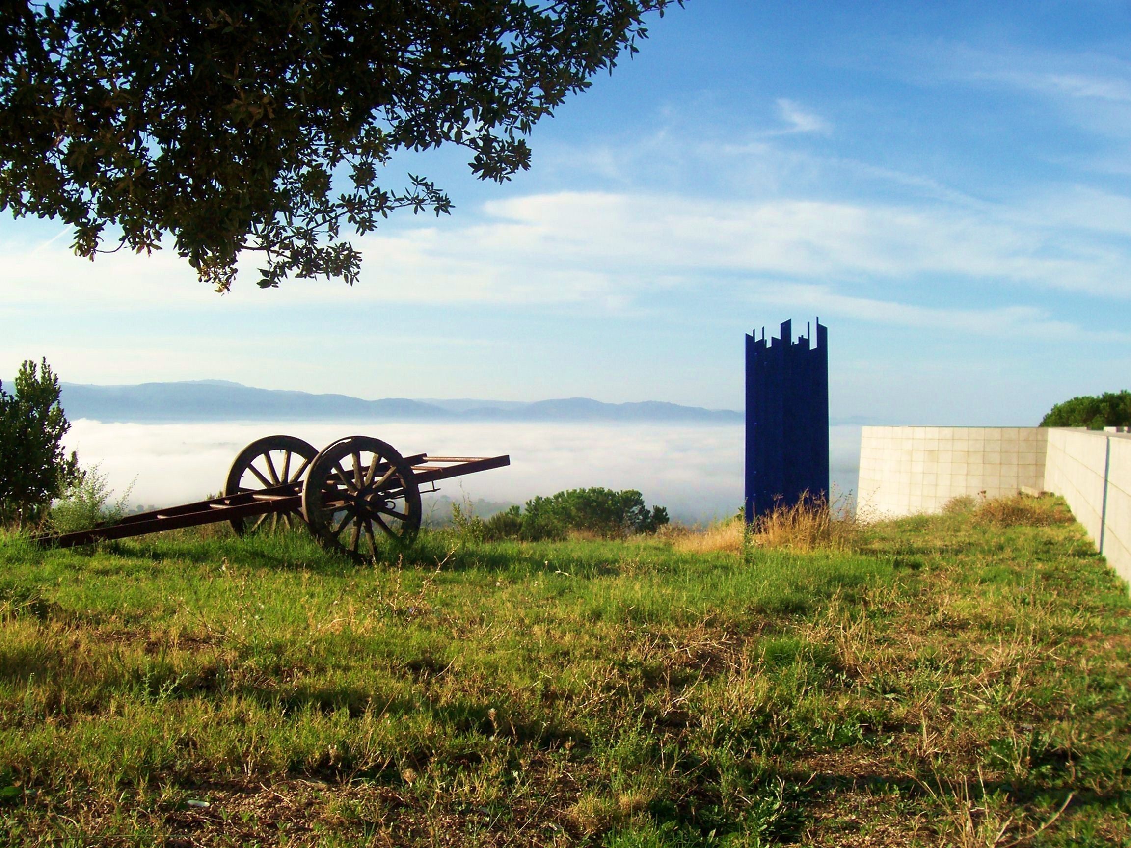 Um campo com um canhão e uma torre alta.