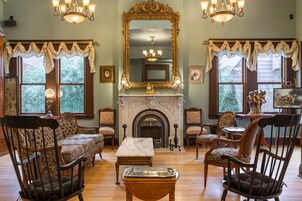 Quarto tradicional com lareira, espelho ornamentado e mobiliário clássico.