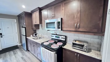 Suite Familiar, várias camas, kitchenette, vista para o lago | Sala de estar | Televisor LED de 50 polegadas com canais via satélite, televisor 