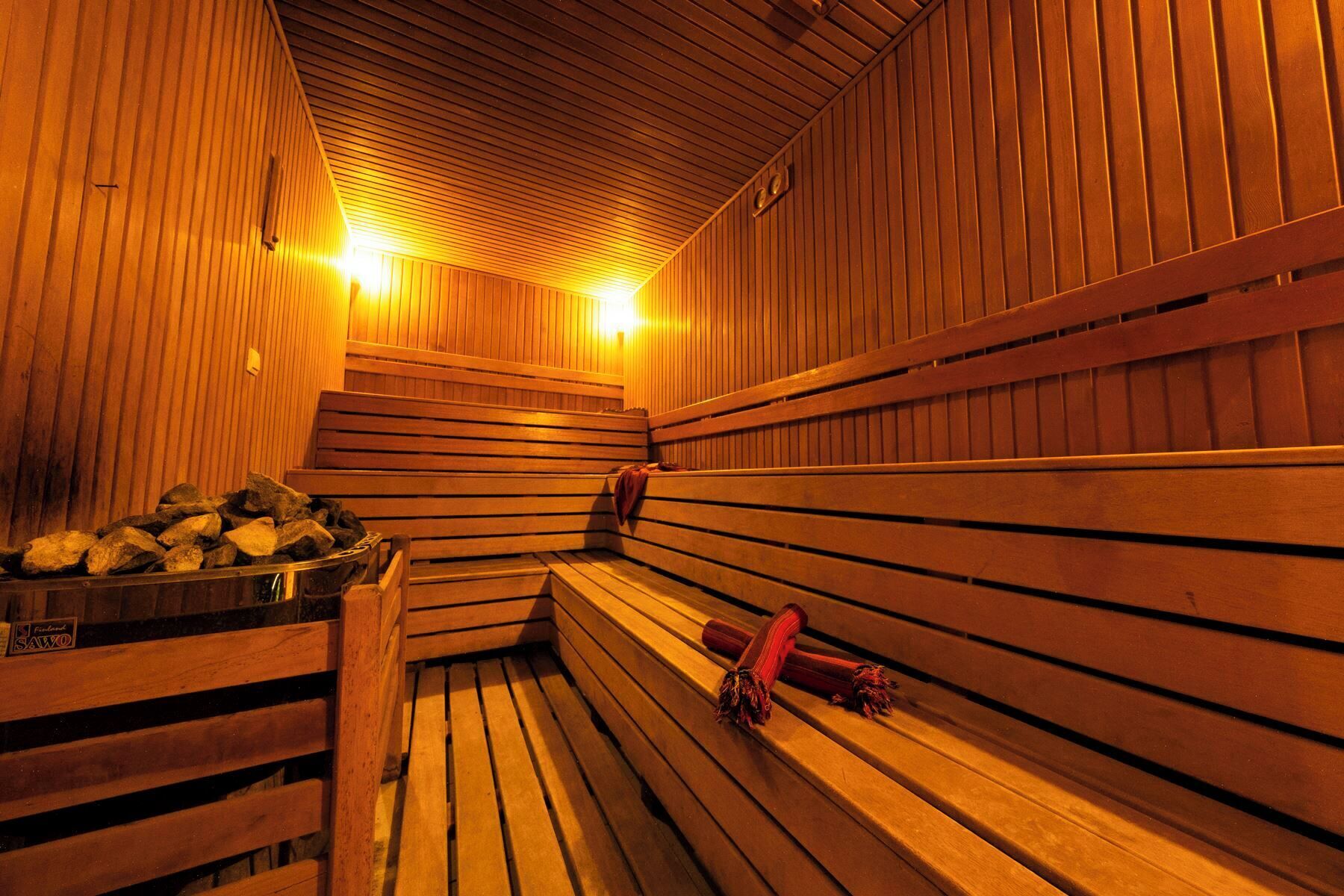 Uma sauna com bancos de madeira e uma pilha de pedras.