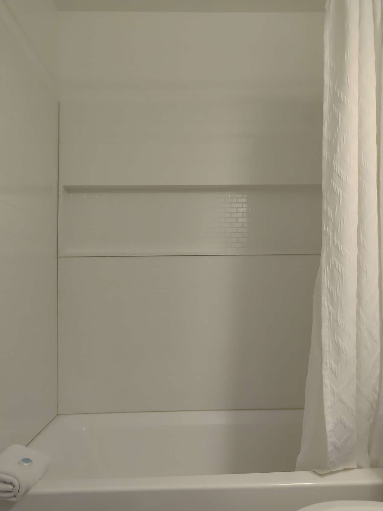 Um banheiro com banheira, porta-toalhas e cortina de chuveiro.