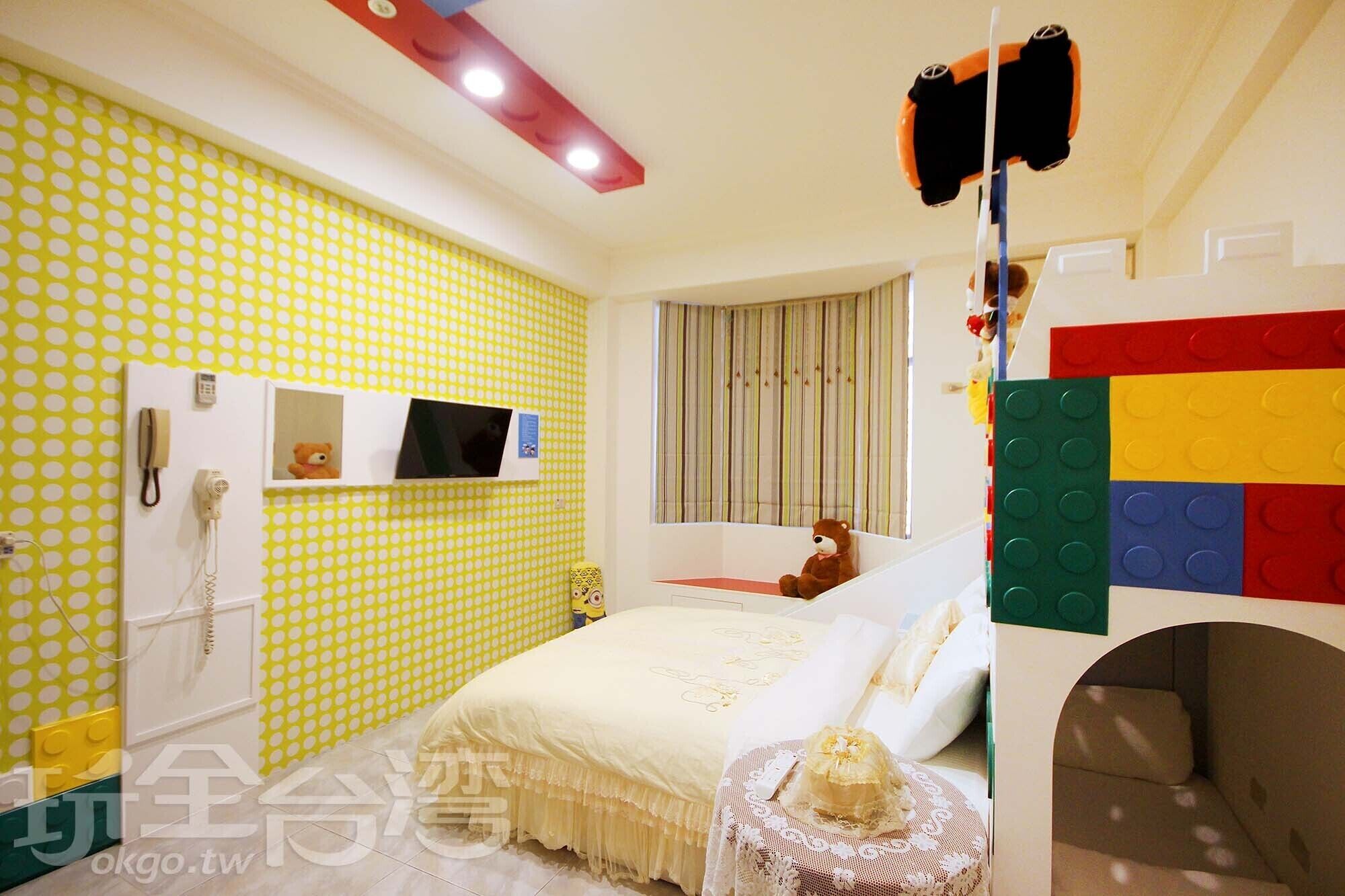 Quarto de criança com cama, espaço para brincar e janela com cortinas.