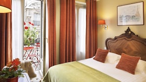 Quarto de hotel com cama, janela com cortinas, planta em vaso e abajur.