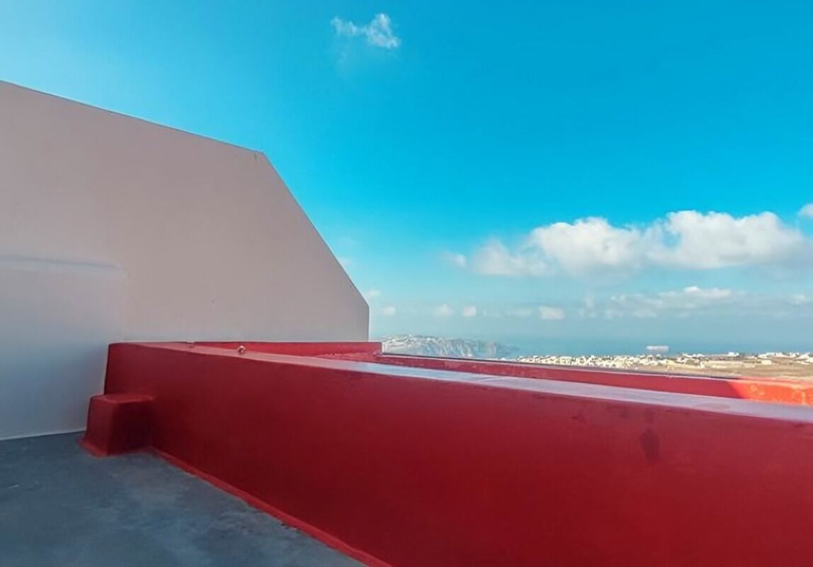 Varanda vermelha com vista ampla do céu e da paisagem distante.