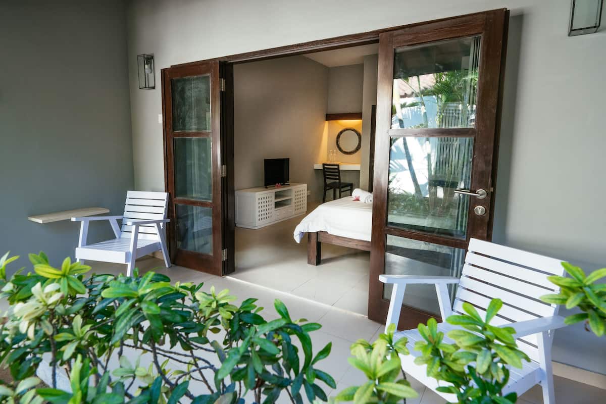 Quarto com cama, escrivaninha, cadeira e um pequeno armário.