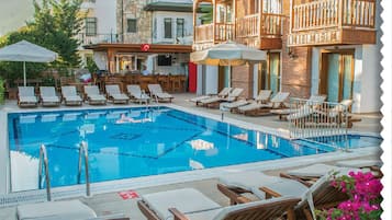 Piscina exterior sazonal, uma piscina com cascata, espreguiçadeiras