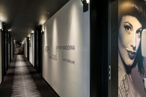 Um corredor com piso estampado, uma parede com texto e um pôster grande.