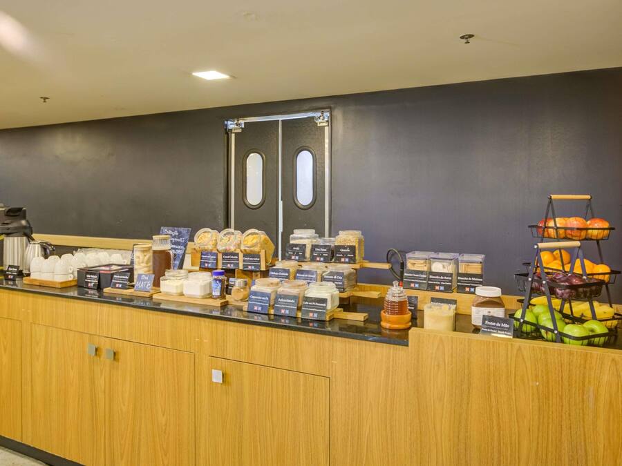 Um balcão de pequeno-almoço com diversas opções de comida e uma máquina de café.