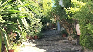 Ruas de paralelepípedos ladeadas por vegetação exuberante e edifícios históricos.