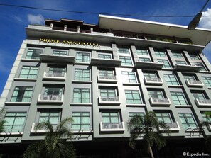 Um hotel com vários andares, varandas e janelas amplas.
