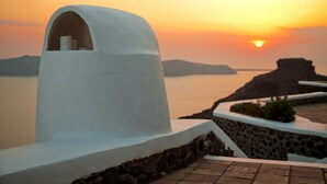 Um edifício branco com uma estrutura em forma de cúpula e uma parede de pedra.
