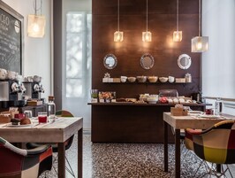 Um café com balcão de madeira, máquinas de espresso e diversas opções de comida.