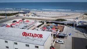 Um hotel com telhado vermelho e vista para a praia e oceano.