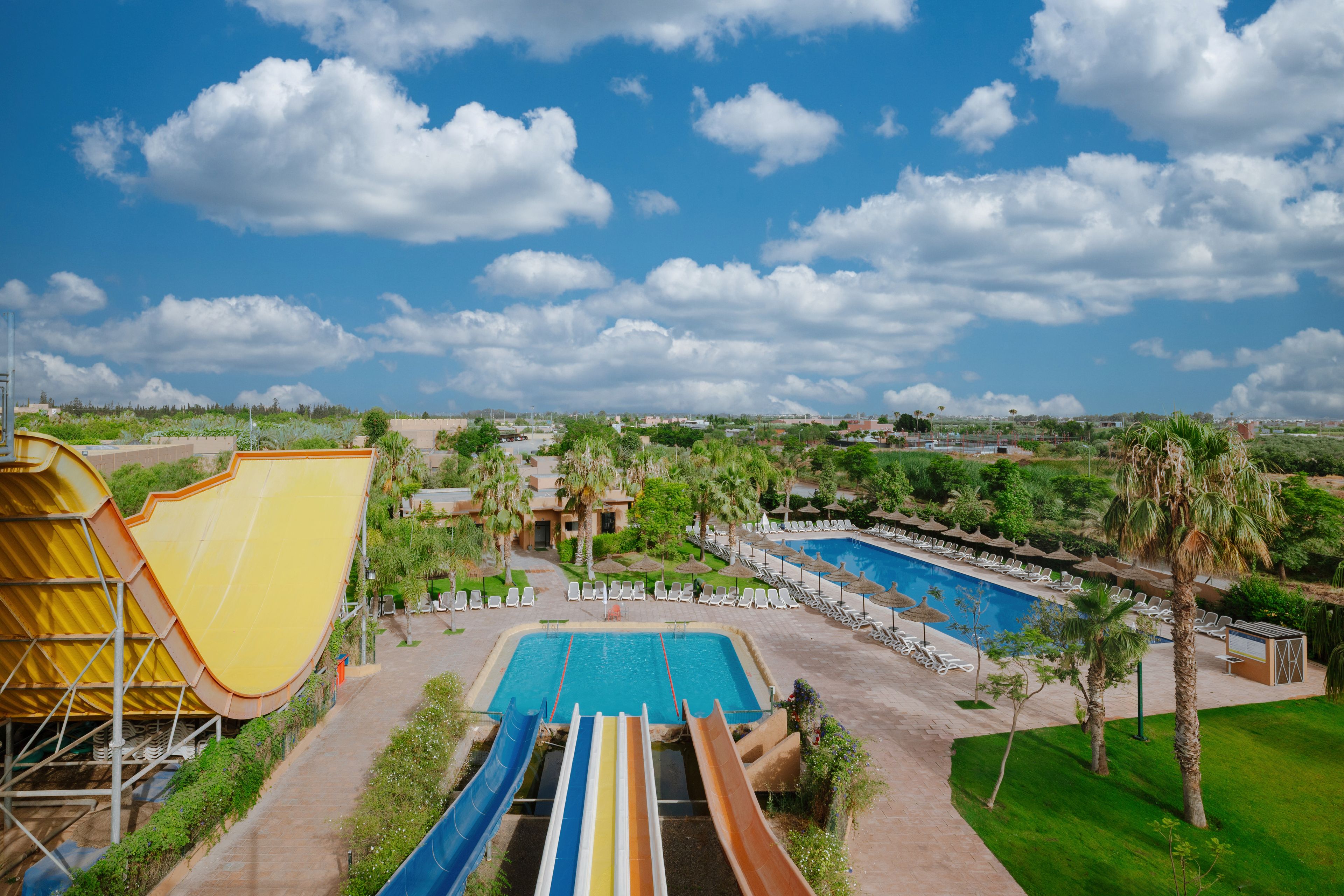 Resort com piscina grande, vários toboáguas e céu claro.
