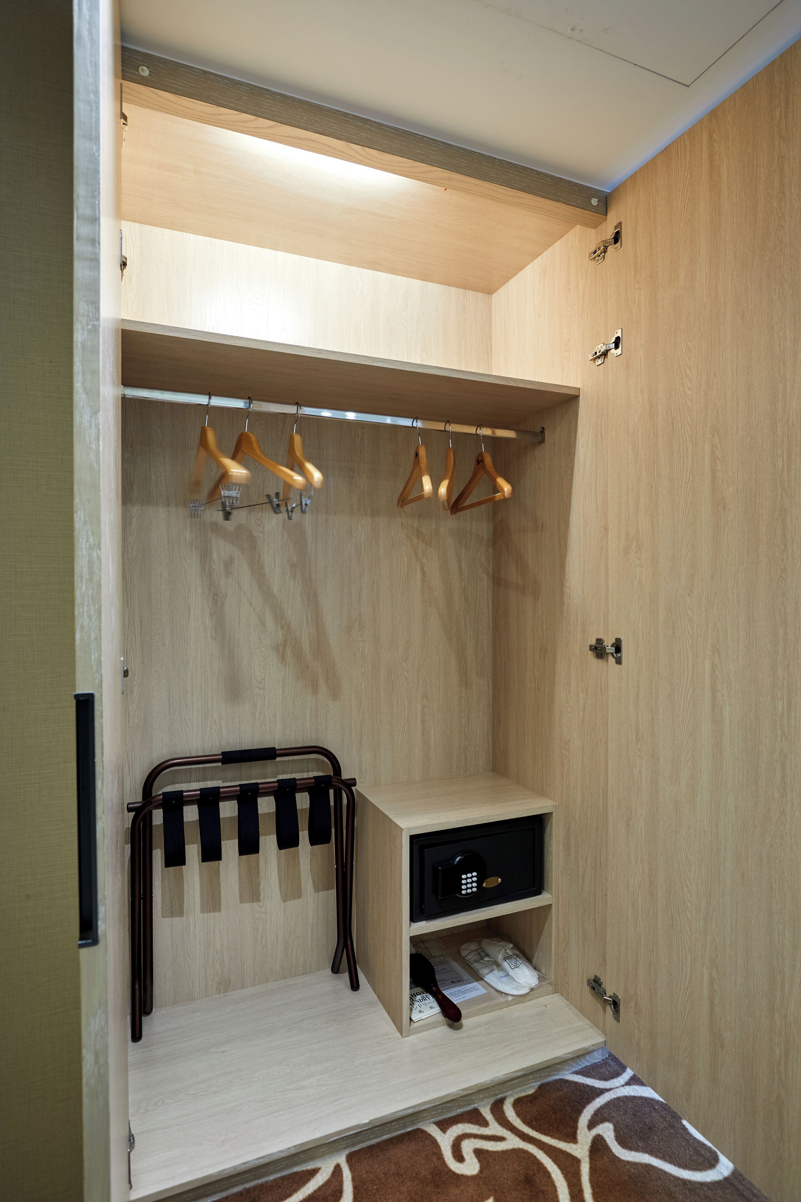 Um closet amplo com portas de madeira, um sapateiro e um cabideiro.