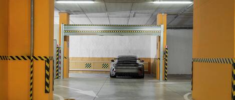 Uma garagem de estacionamento com um carro estacionado sob uma barreira listrada em amarelo e preto.