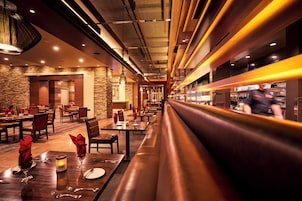 Um restaurante com um balcão comprido, cabines e um espaço de bar.