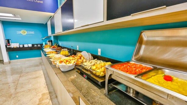 Buffet com diversos alimentos, incluindo frutas, legumes e uma variedade de pratos.