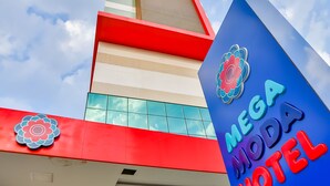 Fachada do Mega Moda Hotel, com uma placa chamativa e design arquitetônico moderno.