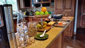 Uma bancada de cozinha com diversos alimentos e eletrodomésticos.